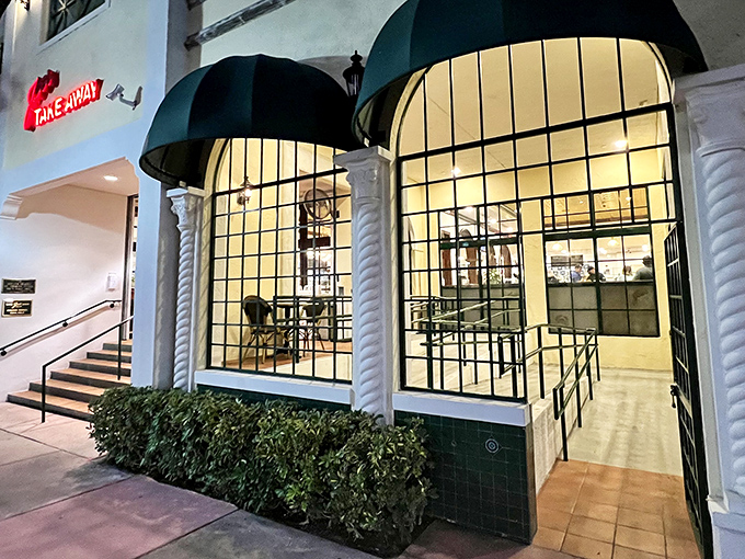 The iconic green awnings of Joe's Take-Away beckon like an old friend at twilight, promising seafood treasures within this Miami Beach landmark. 