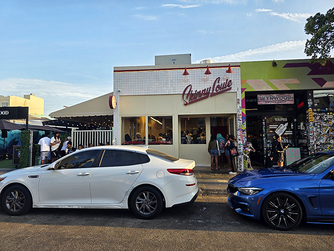 The iconic white-tiled façade with bold red "Skinny Louie" script stands like a beacon of burger hope in Miami's bustling landscape.