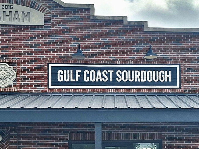 The Graham building stands like a brick-and-mortar food embassy, where Gulf Coast Sourdough's sign promises carb-laden diplomacy alongside its neighbor Rakki Rice & Noodles.