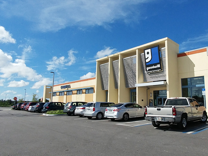 The modern exterior of Goodwill Goldenrod stands like a beacon of bargain hope under Florida's impossibly blue sky, promising air-conditioned treasure hunting inside.