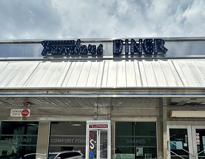 The iconic blue neon sign of Fenders Diner glows with promise, a beacon of comfort food that's been calling hungry travelers home for generations.