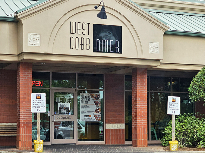 The welcoming facade of West Cobb Diner stands ready to embrace hungry visitors with its brick exterior and classic diner signage.
