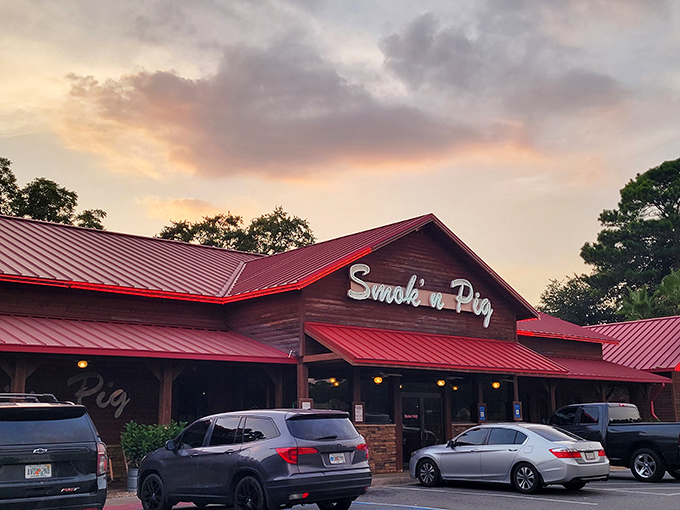 The sunset glow behind Smokin' Pig's rustic wooden exterior and signature red roof feels like nature's way of highlighting where dinner should happen tonight.