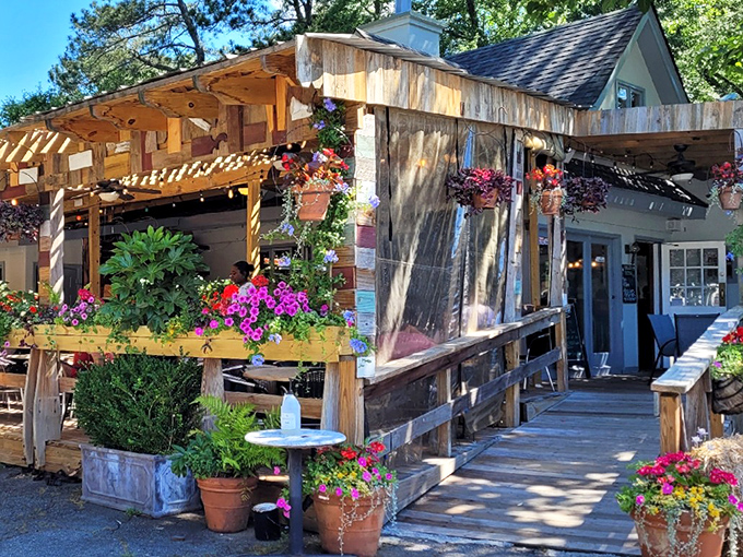 The childhood dream you never outgrew&mdash;a treehouse with food! Weathered wood, vibrant flowers, and that porch practically whispers, "Come sit a while."