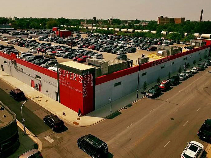 The iconic red exterior of Buyer's Flea Market stands like a retail fortress, its packed parking lot a testament to treasure hunters' dedication.
