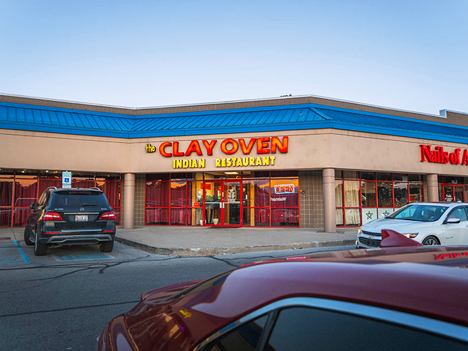The bright blue roof and bold signage of Clay Oven stand out like a beacon of culinary promise in an unassuming strip mall.