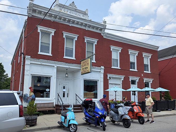 The red brick exterior of Wagner's Village Inn stands proudly in Oldenburg, complete with a colorful rooster guardian and motorcycles that signal good taste is parked here.