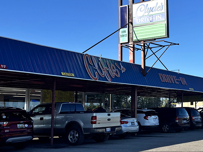 The bright yellow exterior of Clyde's Drive-In stands like a beacon of burger hope against the Michigan sky, promising delicious nostalgia with every visit.