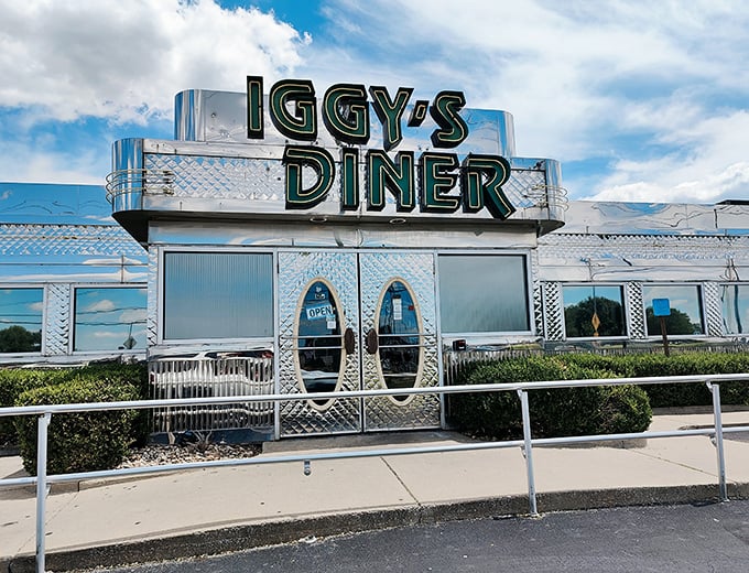 The gleaming silver exterior of Iggy's Diner shines like a time machine to the golden age of Route 66, complete with those iconic oval doors beckoning hungry travelers inside.