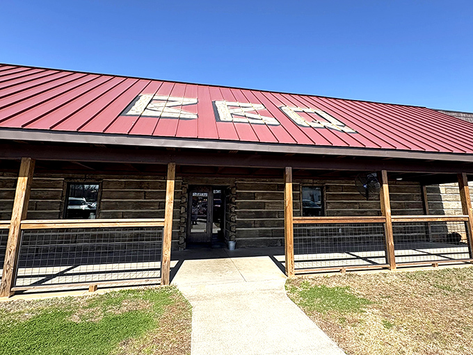 The rustic log cabin exterior with its bright red roof isn't trying to impress anyone&mdash;it's saving all that energy for what's smoking inside.