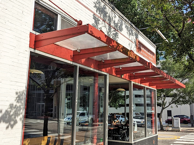 The iconic red awning of Beasley's Chicken + Honey beckons hungry visitors like a Southern lighthouse guiding ships to delicious shores.