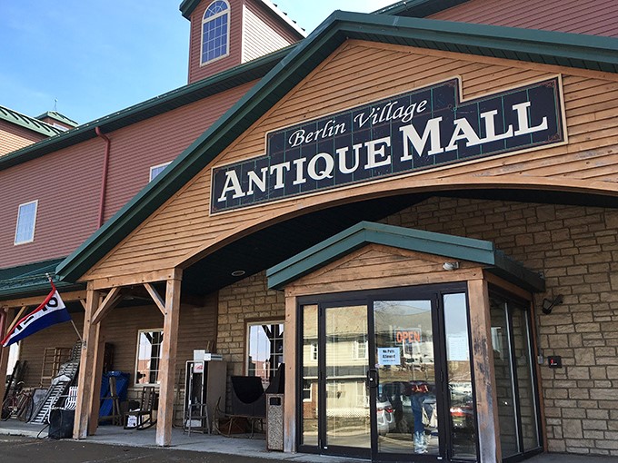 The rustic wooden facade of Berlin Village Antique Mall promises treasures inside like a book cover hints at adventures within.