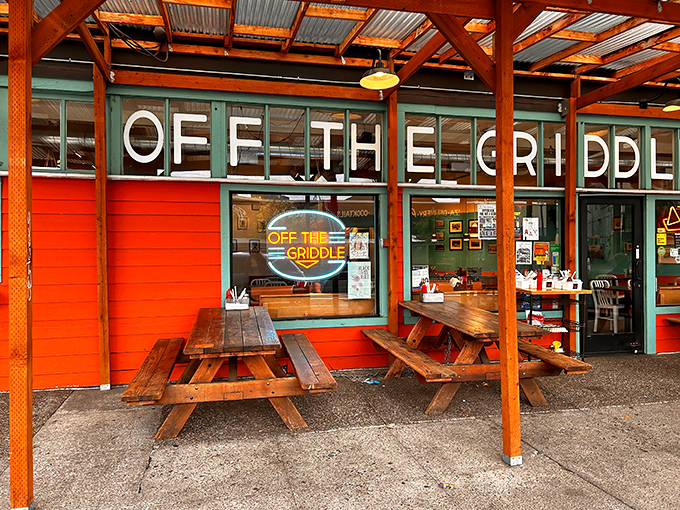 The vibrant orange and teal exterior of Off The Griddle beckons like a tropical oasis in Portland's urban landscape. Those picnic tables have heard some stories.