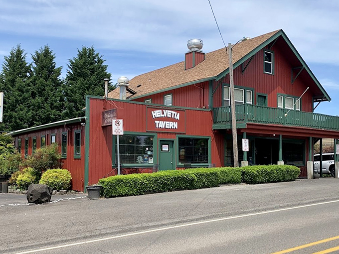 The iconic red exterior of Helvetia Tavern stands like a culinary lighthouse in rural Hillsboro, beckoning hungry travelers with promises of burger perfection.