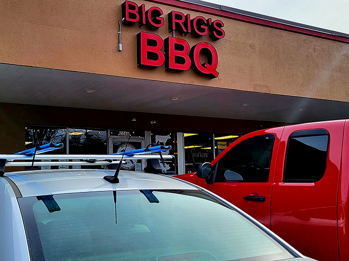 The bright red sign of Big Rig's BBQ stands out like a beacon for meat lovers, promising smoky delights within this unassuming Monroeville strip mall location.