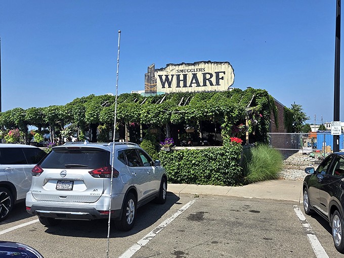 Nature's slowly reclaiming this maritime treasure, with vines embracing the weathered sign like old friends reuniting at a high school reunion.