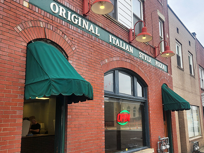 The iconic brick fa&ccedil;ade with green awnings doesn't scream "food destination," but locals know this unassuming storefront houses pizza worth committing minor traffic violations for.