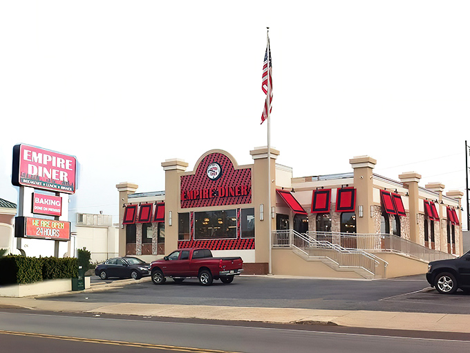 The grand exterior of New Empire Diner stands like a beacon for hungry travelers, its distinctive red awnings and American flag promising classic comfort with a touch of glamour.