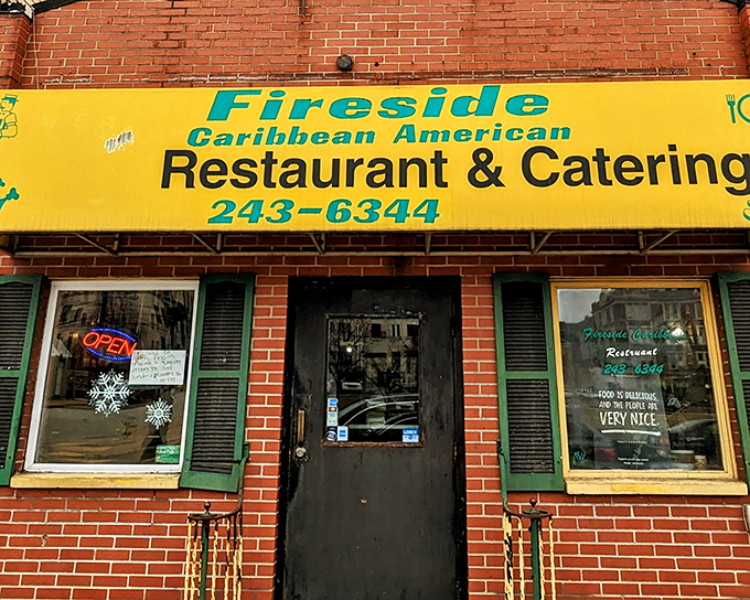 The bright yellow awning of Fireside Caribbean beckons like a tropical sun in Pittsburgh's urban landscape. Caribbean paradise awaits inside!