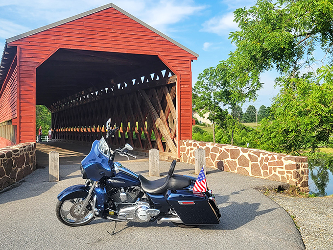 A classic American motorcycle stands sentinel at the entrance to this crimson time capsule, where history and horsepower create perfect harmony.