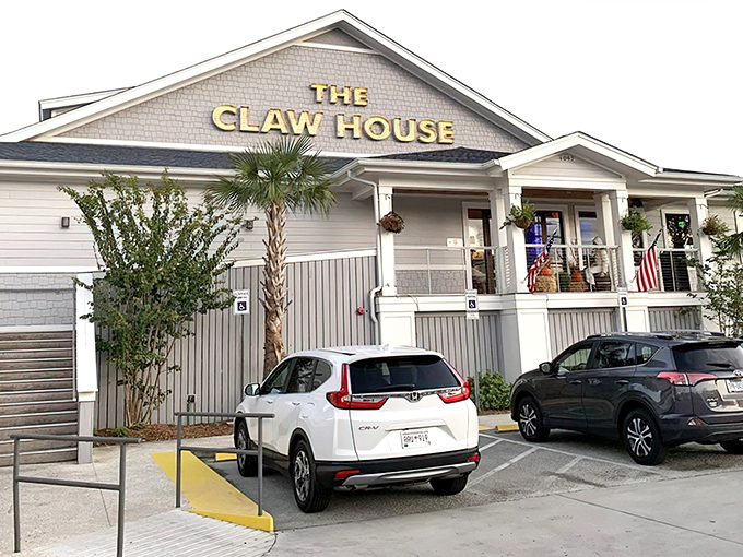 The coastal charm of The Claw House beckons seafood lovers with its classic gray and white exterior. A palm tree stands guard, promising a taste of Maine in Murrells Inlet.