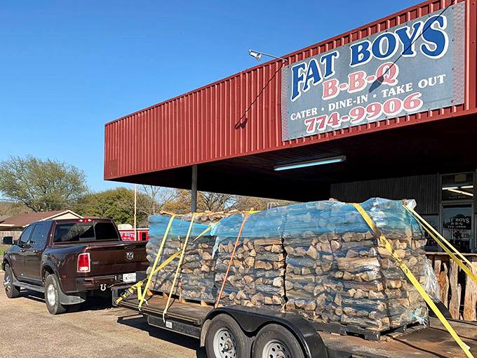 The unmistakable red exterior of Fat Boy's BBQ stands as a beacon of hope for hungry travelers. That trailer of wood isn't decoration&mdash;it's serious smoking business.