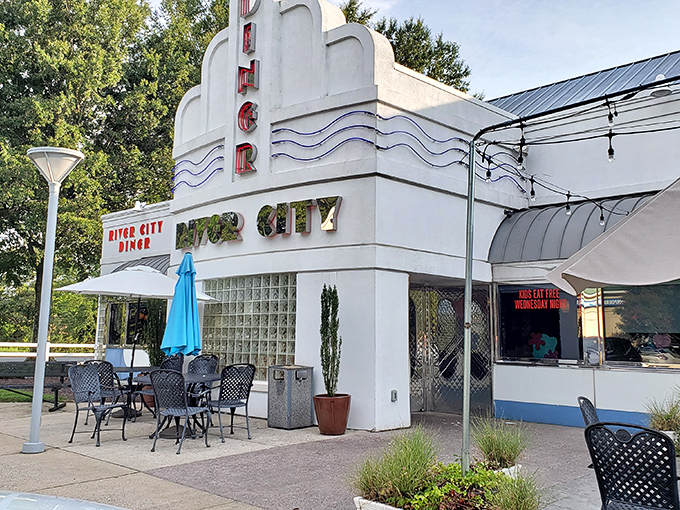 The sleek, retro-modern exterior of River City Diner beckons with its distinctive blue trim and inviting patio seating&mdash;a roadside oasis for hungry travelers.