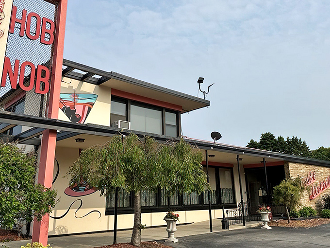 The mid-century stone facade of HOBNOB stands proudly against the Wisconsin sky, its "Food & Cocktails" sign promising delicious memories in the making.
