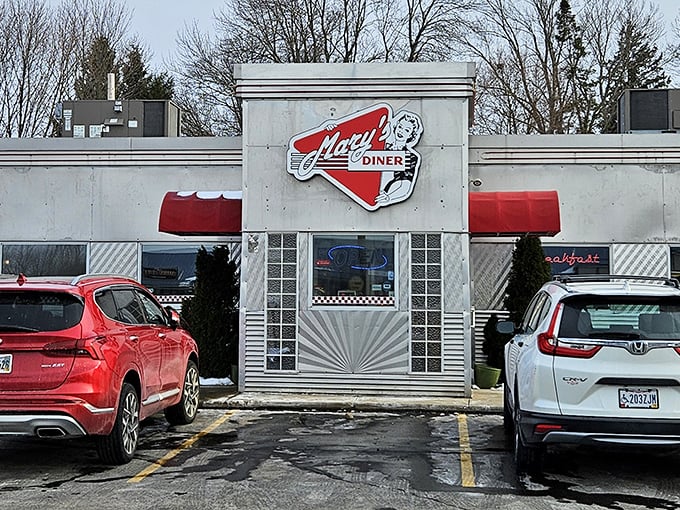 The iconic red triangle sign of Mary's Diner beckons hungry travelers like a neon lighthouse guiding ships to breakfast harbor.