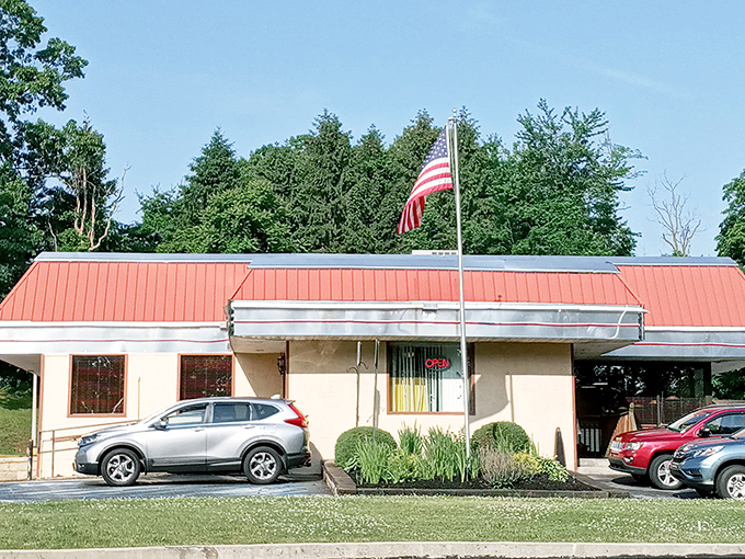 The classic red roof and American flag announce this diner's mission before you even step inside: authentic food without pretense.