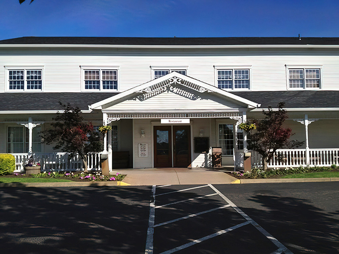 The grand white and brick exterior of Amish Door Restaurant stands like a beacon of comfort food amid Ohio's rolling countryside. That wraparound porch practically whispers "come sit a while."