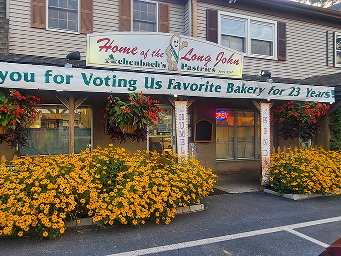 The welcoming facade of Achenbach's Pastries, where vibrant marigolds and hanging baskets create the perfect prelude to the sweet treasures within.