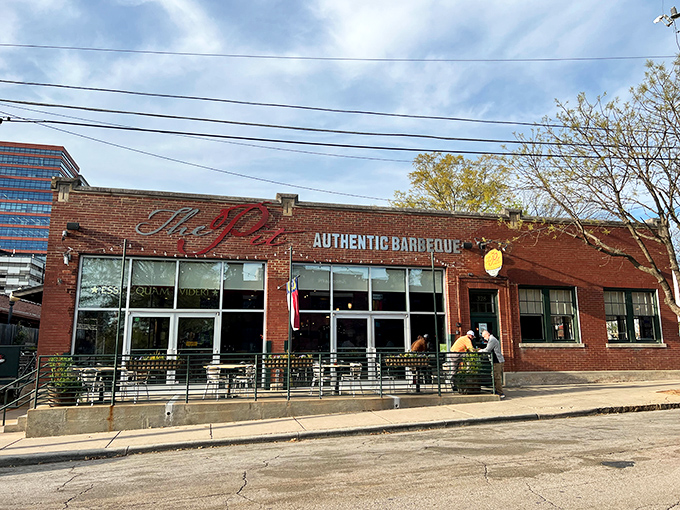 The brick exterior of The Pit beckons like a barbecue beacon in downtown Raleigh, promising smoky treasures within those unassuming walls.