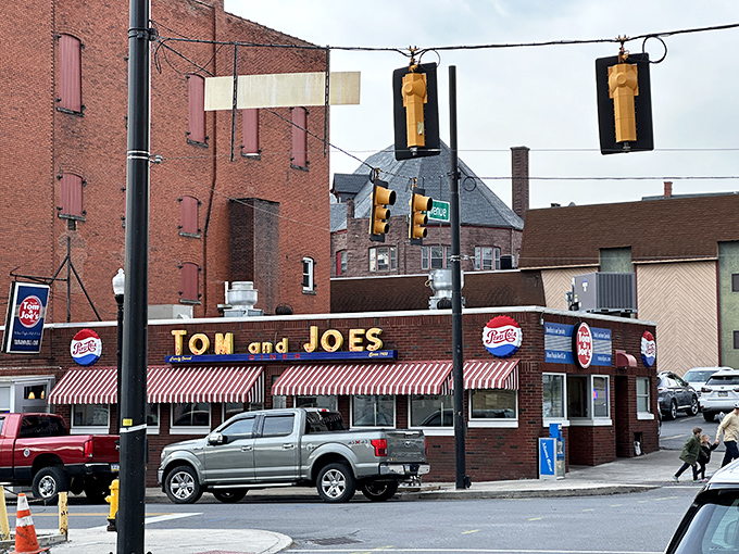 The iconic red-and-white striped awning of Tom & Joe's stands like a culinary lighthouse in downtown Altoona, beckoning hungry travelers to safe harbor.