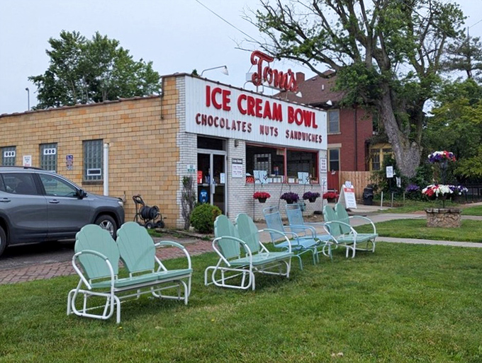 The brick exterior of Tom's Ice Cream Bowl stands as a beacon of sweet nostalgia, complete with mint-green chairs where happiness is served daily.