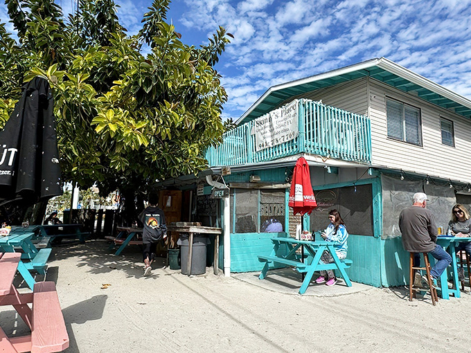 The turquoise-painted shack with wooden deck screams "Florida beach burger joint" louder than a seagull eyeing your fries. Old-school charm personified.