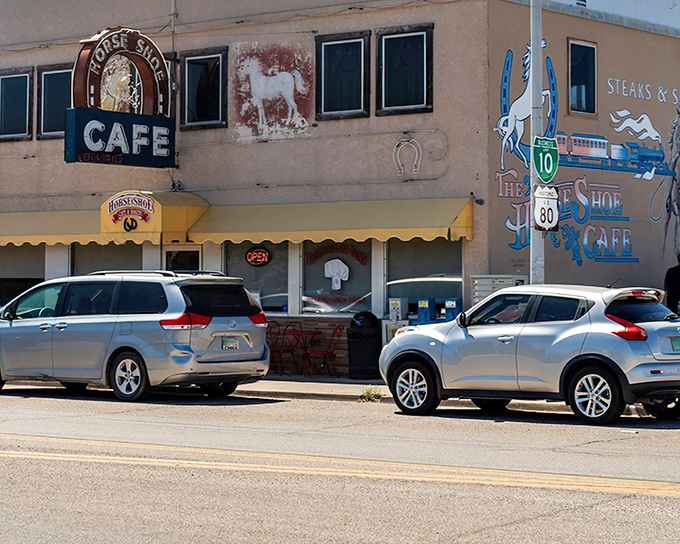 The iconic facade of The Horseshoe welcomes hungry travelers with its charming horse paintings and classic black-and-white striped awning—a beacon of comfort food in Benson.
