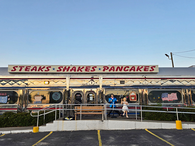 The gleaming silver exterior of All American Diner shines like a time capsule under the Florida sun, promising "STEAKS &bull; SHAKES &bull; PANCAKES" in bold red letters.