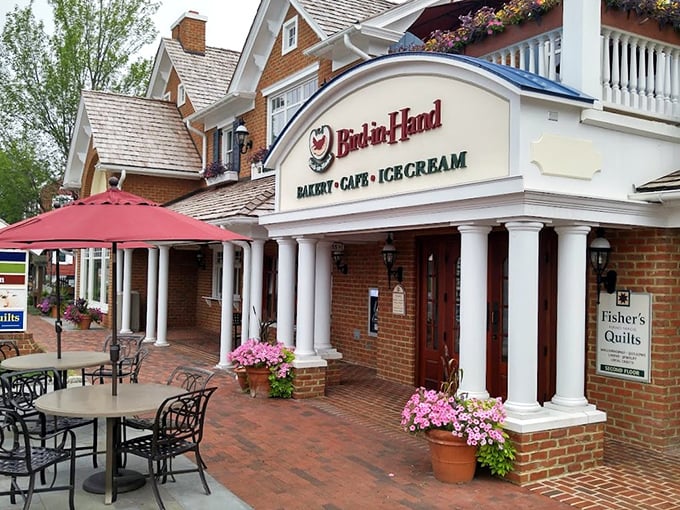 The charming blue and brick exterior of Bird-in-Hand Bakery & Cafe stands like a delicious mirage in Amish Country, complete with inviting porch seating.