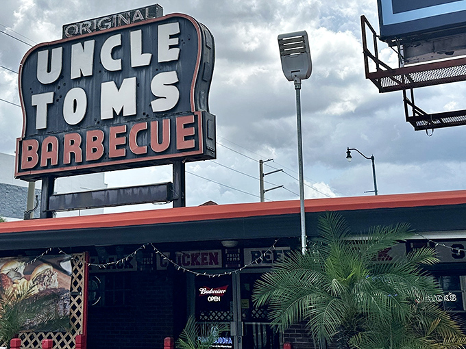 The iconic red neon sign of Uncle Tom's Barbecue glows like a beacon for hungry souls wandering through Miami's night, promising smoky salvation just steps away.