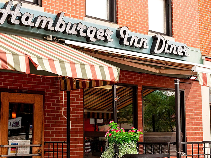 The iconic neon sign of Hamburger Inn Diner beckons hungry travelers like a lighthouse for comfort food enthusiasts navigating downtown Delaware.