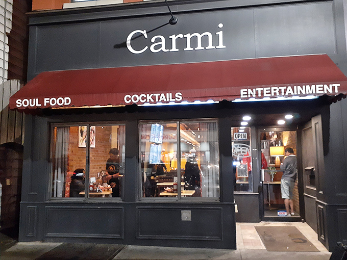 The iconic red awning of Carmi Soul Food beckons hungry travelers like a Southern lighthouse guiding ships to comfort food harbor.