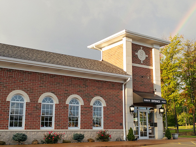 The brick clock tower entrance at Guido's Pizza Haven stands like a culinary lighthouse, beckoning hungry travelers through Chesterland's snow-dusted landscape.