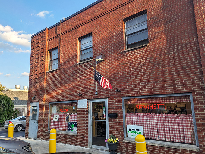 The unassuming brick exterior of Rubino's stands like a time capsule on East Main Street, its vintage neon sign a beacon for pizza pilgrims.