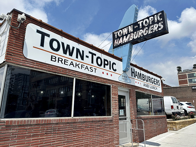 The iconic Town Topic sign stands proud against the Missouri sky, a beacon of burger perfection since 1937 that's outlasted countless food trends.