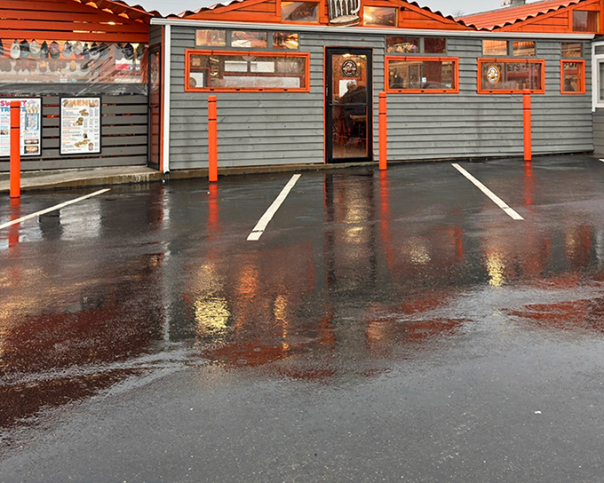 The unassuming gray exterior with bright orange trim stands like a time capsule of Americana, beckoning hungry travelers with promises of nostalgic flavors.