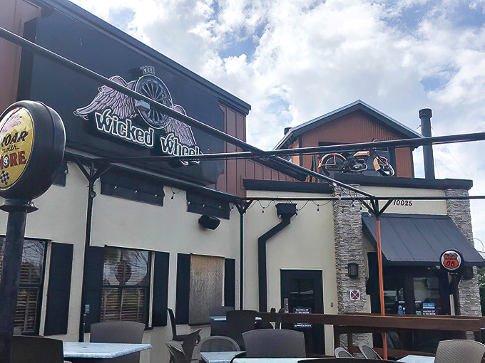 The Wicked Wheel's exterior promises adventure with its winged logo and rustic charm. Motorcycle theme outside, culinary magic inside.