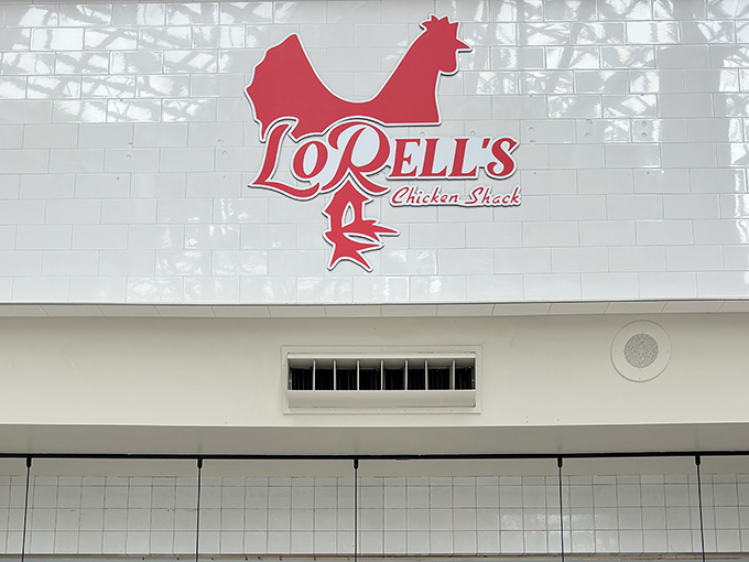 The iconic red rooster logo of LoRell's Chicken Shack stands out against pristine white tiles, beckoning chicken lovers like a culinary lighthouse.