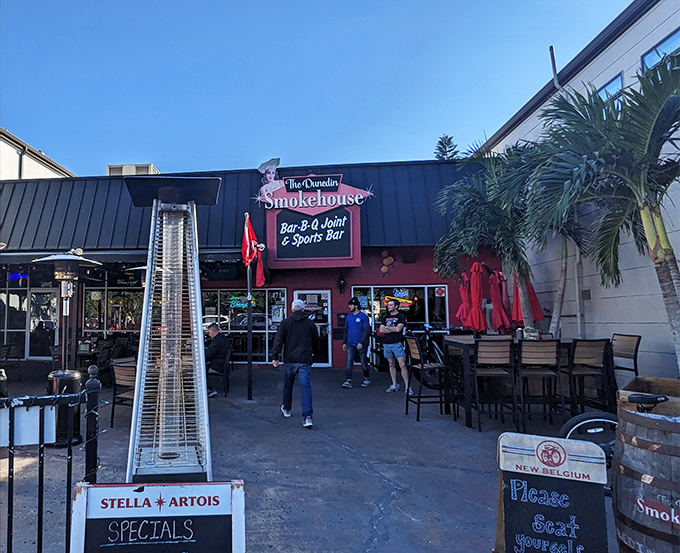 The vibrant red exterior of The Dunedin Smokehouse welcomes hungry visitors with its unpretentious charm. This is where BBQ dreams come true in downtown Dunedin.