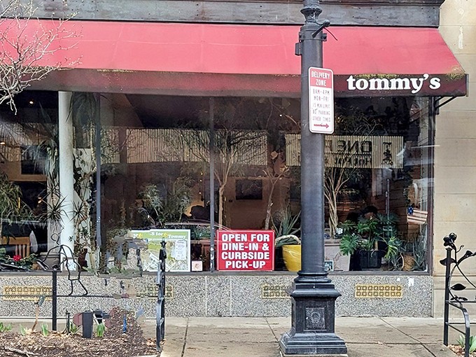 Tommy's iconic red awning beckons hungry Clevelanders like a culinary lighthouse. The storefront's lush plants hint at the fresh goodness waiting inside.